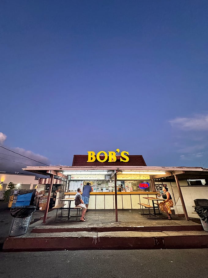 As day turns to dusk, Bob's transforms into a beacon of hope for hungry souls. The neon "OPEN" sign whispers sweet promises of smoky delights.