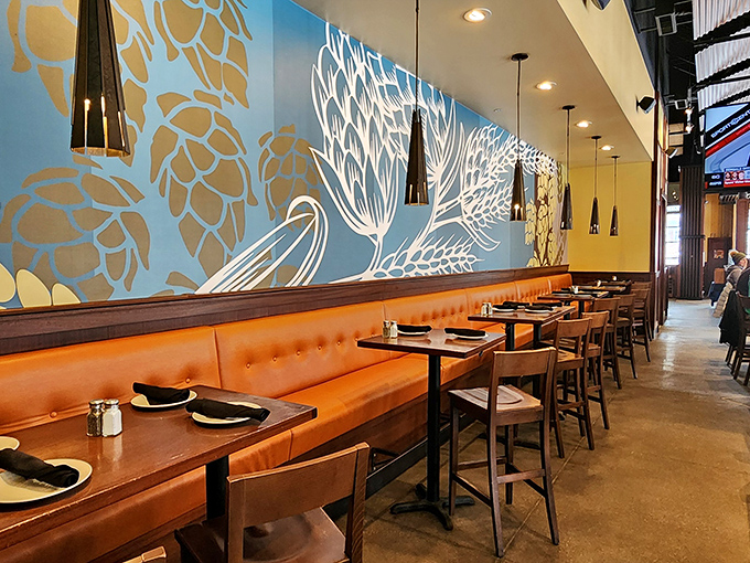 Hop-inspired artwork dances across blue walls while cozy orange booths invite lingering conversations. The kind of place where "just one more beer" becomes three.