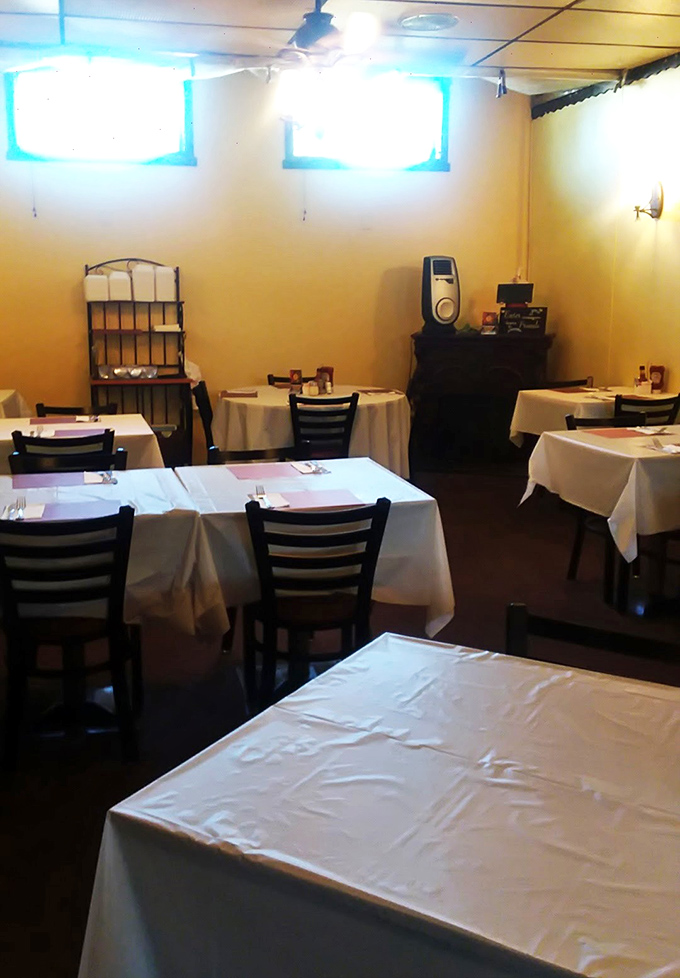 White tablecloths and simple furnishings set the stage where food, not decor, is the undisputed star of the show.