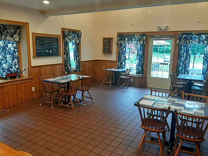 Step into a Norman Rockwell painting come to life. This cozy interior, with its wooden chairs and floral curtains, whispers tales of countless shared meals.