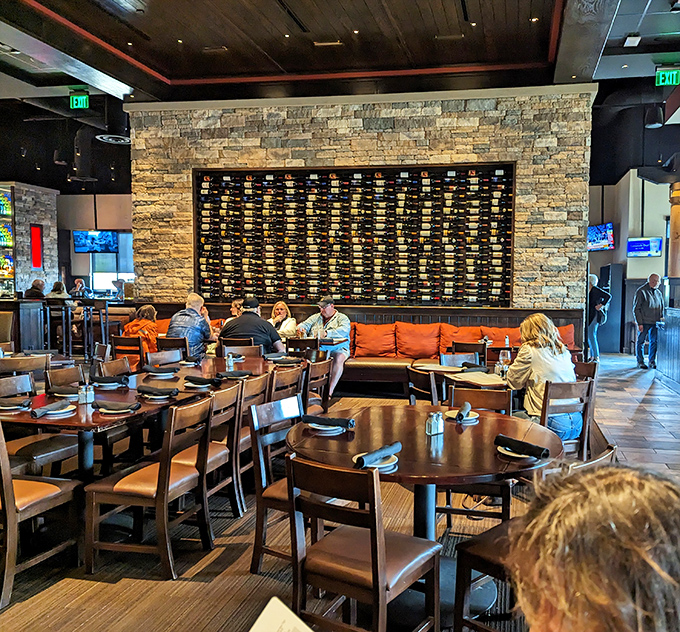 Step into a dining room that's part steakhouse, part wine cellar, and all inviting. That stone wall of bottles isn't just decor—it's a sommelier's playground!