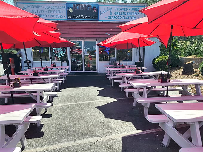 Pastel picnic tables and red umbrellas? It's like the beach decided to throw a party, and King Neptune's is hosting the seafood soir&eacute;e!