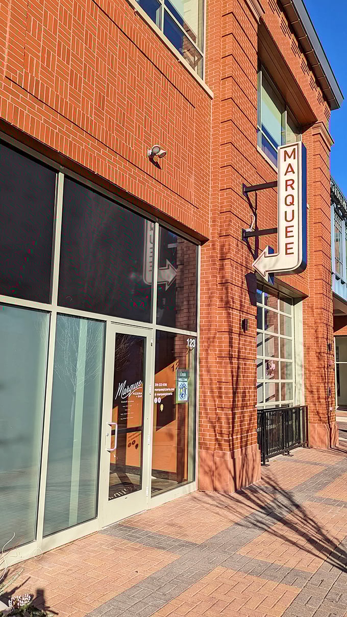 Marquee's sleek brick exterior and modern signage hint at the wood-fired wonders awaiting inside this Coralville gem.