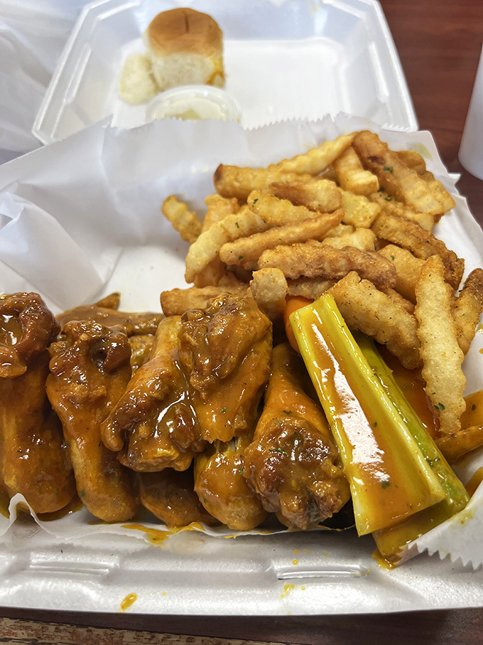Golden-fried wings glistening with that signature orange sauce, served with crispy fries and celery. A perfect trifecta of textures and flavors.
