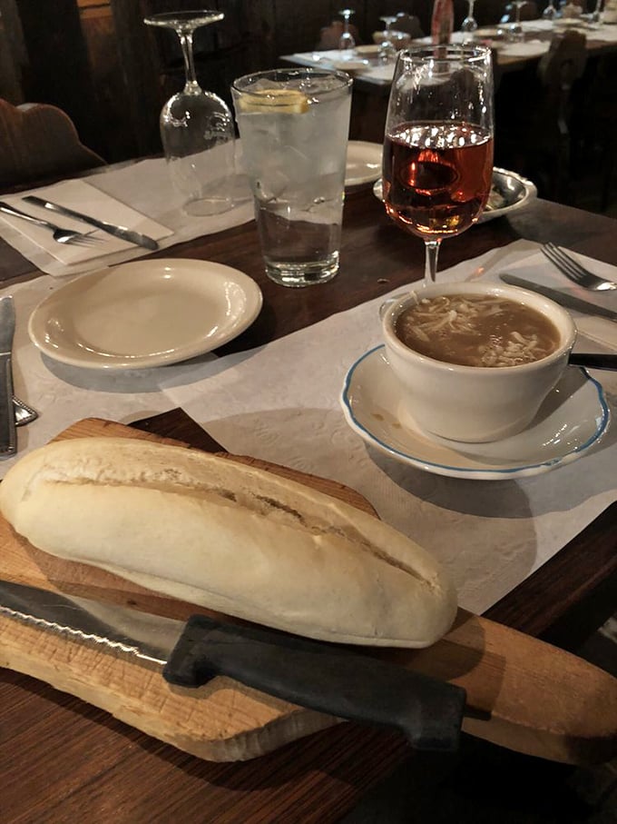The holy trinity of comfort: French onion soup, crusty bread, and a glass of blush. It's like a warm hug for your taste buds.