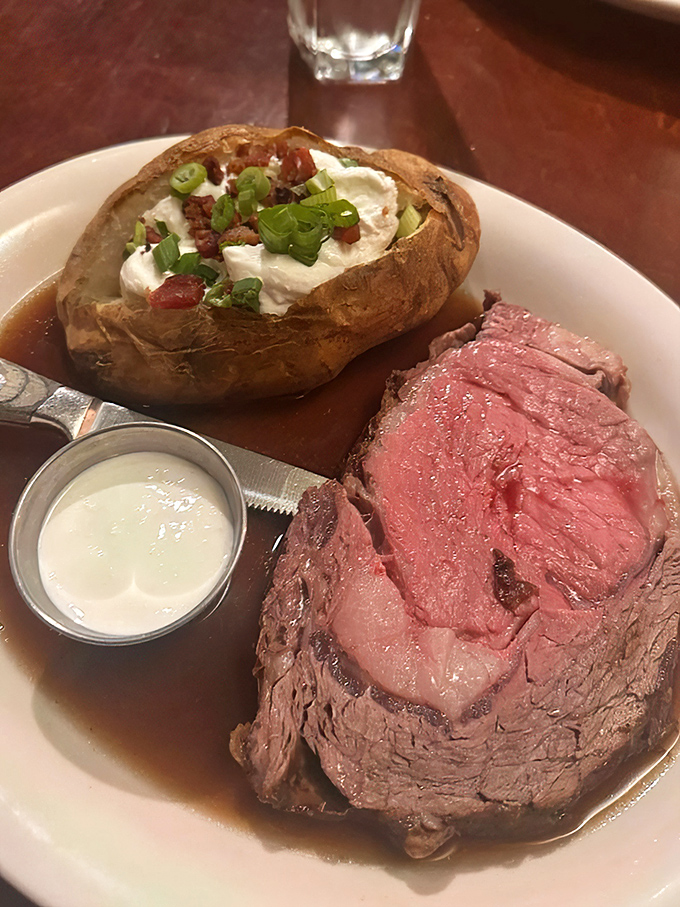 Meat paradise found! This plate showcases why people drive across state lines&mdash;perfectly pink prime rib paired with a loaded Idaho potato that's practically a meal itself.