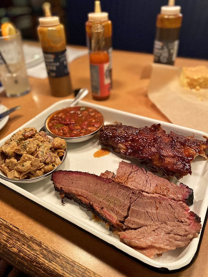 Behold the holy trinity of BBQ perfection: brisket with that telltale smoke ring, ribs glazed to glossy perfection, and beans that have clearly been taking notes.