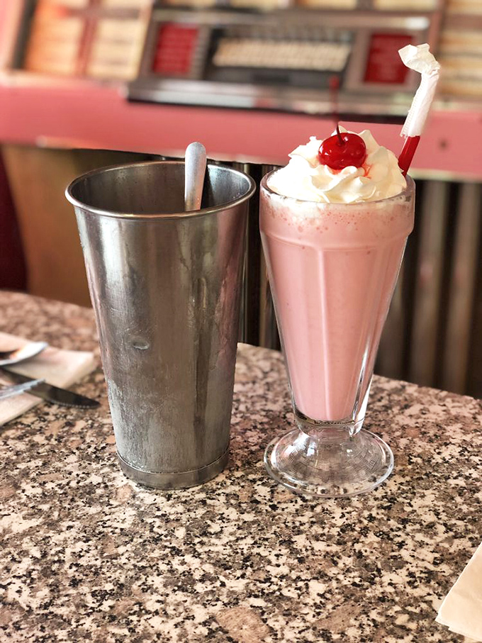 Pink perfection in a glass! This strawberry milkshake looks so good, it might just make you break into song like Danny Zuko at the Frosty Palace.
