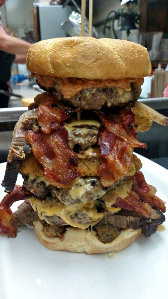 Holy cow! This burger's so tall, it needs its own zip code. It's not a meal, it's a delicious skyscraper of beef and toppings.