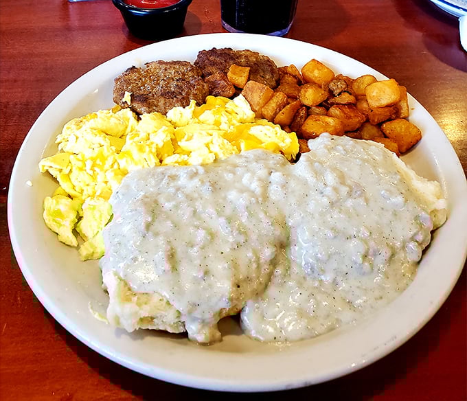 Breakfast of champions! Golden biscuits swimming in creamy gravy, with eggs and potatoes as trusty sidekicks. Morning perfection on a plate.