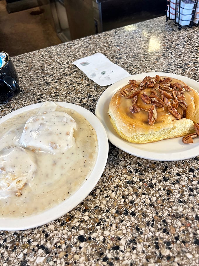 The dynamic duo of diner delights! Biscuits and gravy paired with a cinnamon roll &ndash; it's like comfort food got married and had a delicious baby.