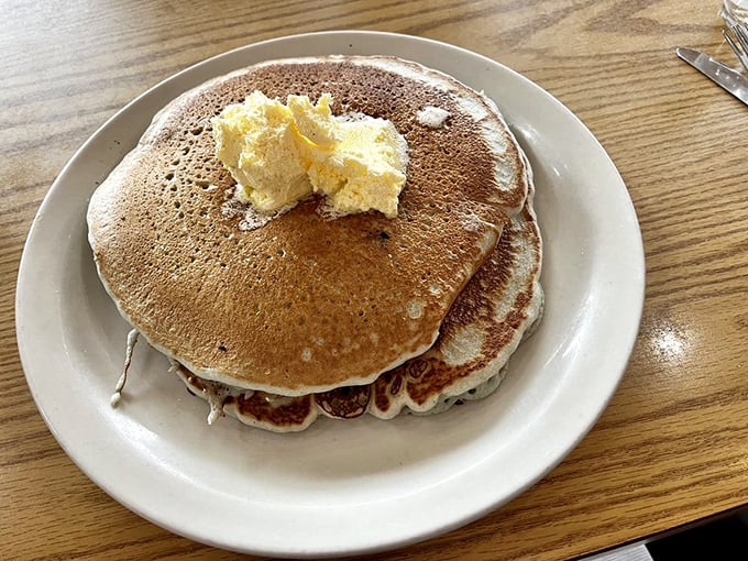 Stack attack! These fluffy pancakes are so tall, they might need their own zip code. Butter melts like a warm hug on top.