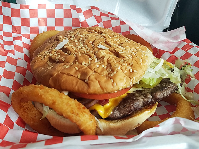 The star of the show takes center stage. This cheeseburger isn't just a meal; it's a work of art on a sesame seed bun.