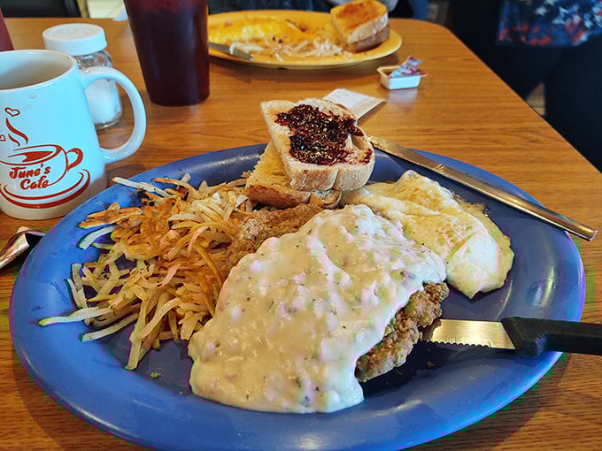 Country-fried steak swimming in creamy gravy alongside crispy hash browns &ndash; proof that sometimes the best things in life come smothered in goodness.