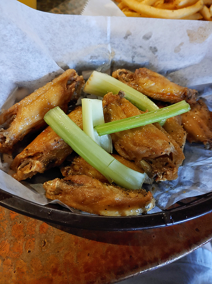 Wings so good, they'll make you forget your table manners! These crispy delights are accessorized with celery sticks – nature's toothpicks for the sophisticated wing enthusiast.