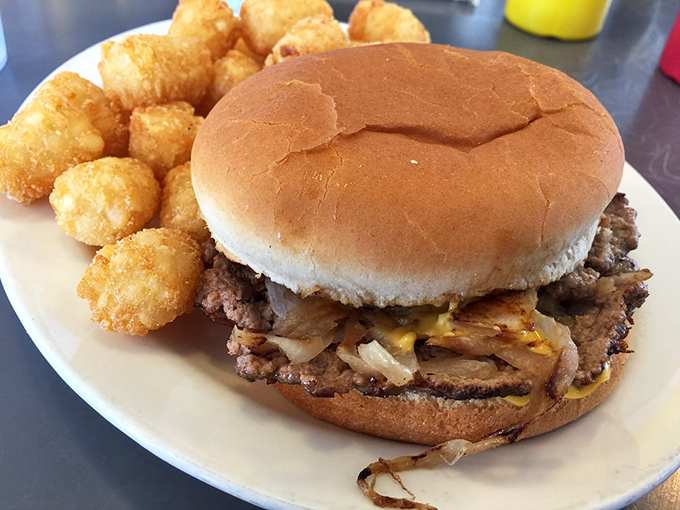 Holy moly, that's a burger! Behold the double cheeseburger in all its glory, flanked by golden tater tot sentinels.
