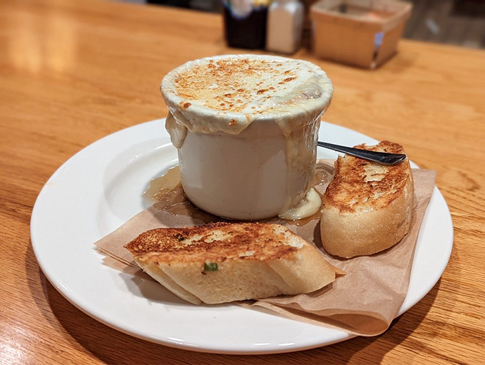 Cheese, please! The Kettle's French Market Onion Soup arrives like a culinary hug, its golden cheese canopy barely containing the savory treasures beneath.