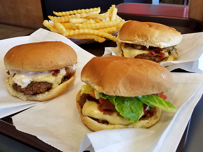 Burger bliss, times three! These handcrafted beauties are stacked higher than your grandkid's Lego towers, and twice as impressive.