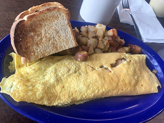 Behold, the omelet that ate Manhattan! This golden giant, flanked by crispy potatoes and hearty toast, is ready to conquer your hunger pangs.