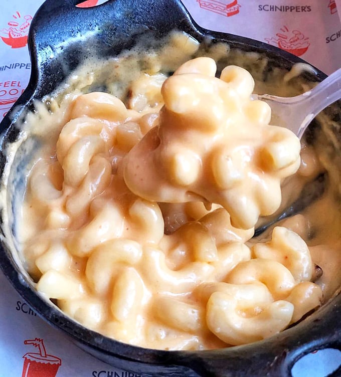 Mac and cheese so creamy it should require a lifeguard on duty. Each perfectly coated elbow of pasta is a tiny vessel of cheese-laden joy.