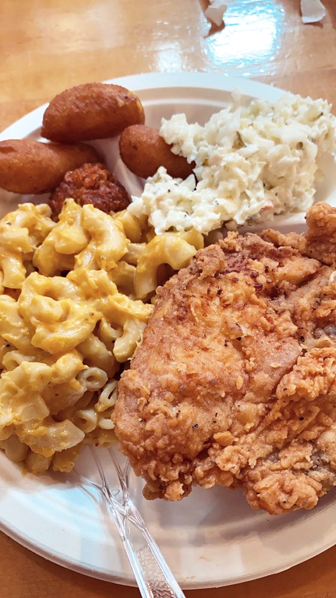 The Holy Trinity of Southern cuisine: golden mac and cheese, perfectly fried chicken, and those hush puppies looking like little orbs of cornmeal heaven.