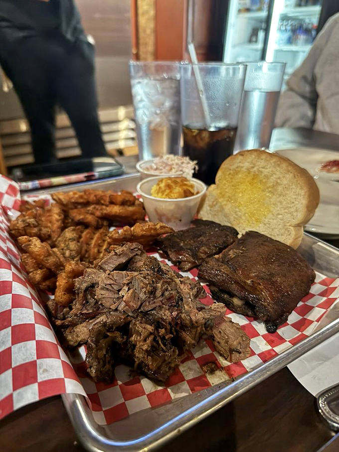 BBQ platter nirvana: where smoke-kissed meats, crispy sides, and Texas toast converge on a metal tray that's seen thousands of happy customers.