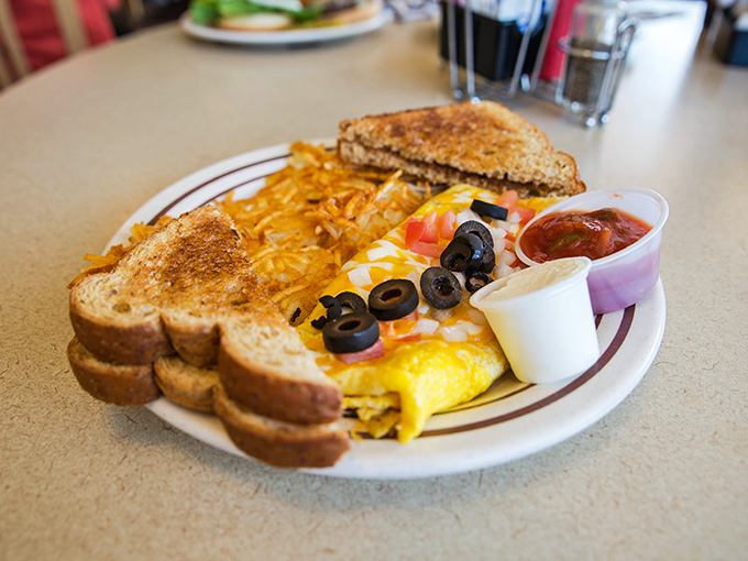 Eggs-cellence on a plate! This omelet is so fluffy, it might just float away if not for the anchor of crispy hash browns and perfectly toasted bread.
