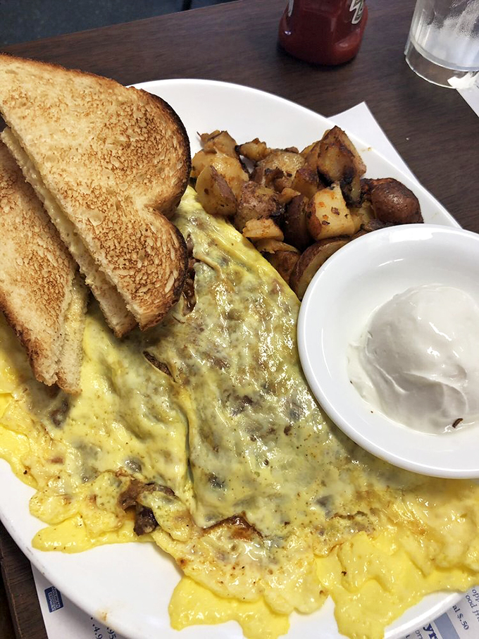 Holy cow, that's one hearty omelet! It's so fluffy and cheesy, it might just float off the plate. Paired with those crispy potatoes, it's a breakfast of champions.