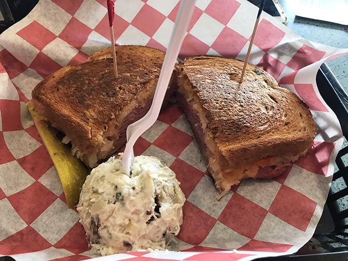 The Reuben arrives like a monument to sandwich engineering, with potato salad standing by for creamy, cooling support.