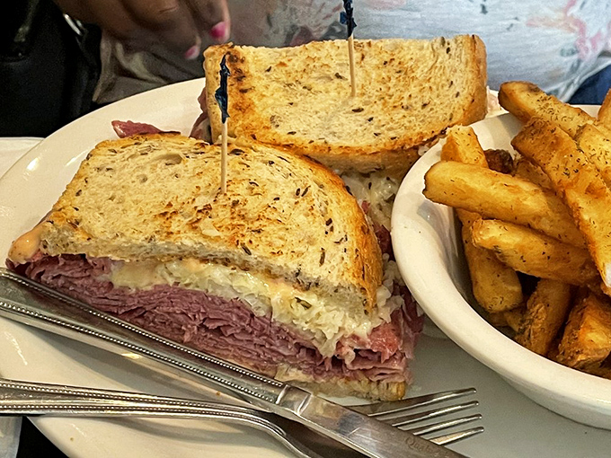 The Reuben in its natural habitat: perfectly grilled rye bread housing a mountain of corned beef. This isn't a sandwich&mdash;it's architecture.