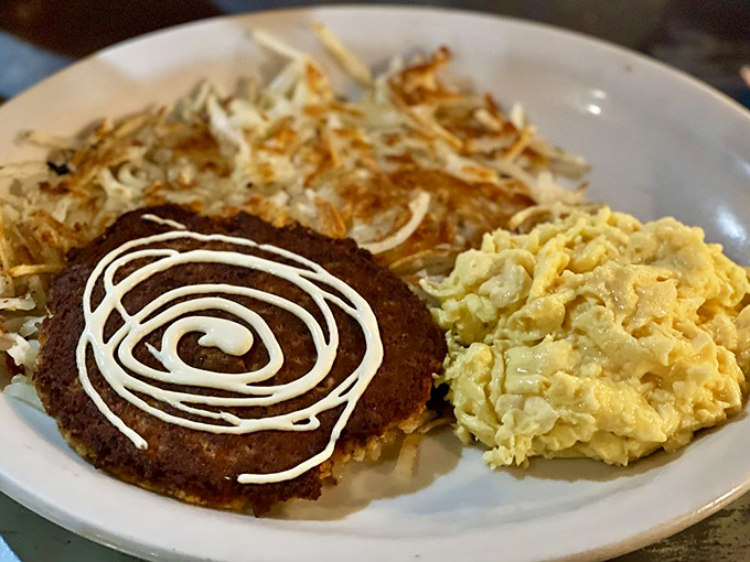 The holy trinity of breakfast: a golden salmon cake, fluffy scrambled eggs, and crispy hash browns that could make a potato proud.