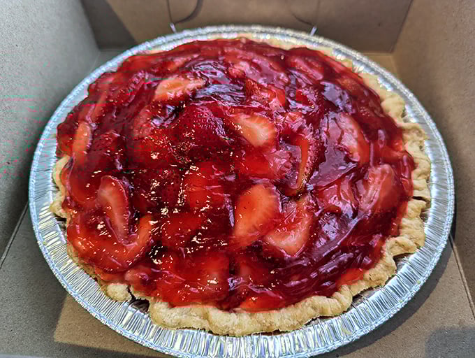 This strawberry pie isn't just dessert; it's summer captured in a tin, with berries swimming in ruby glaze that would make Dorothy's slippers jealous.
