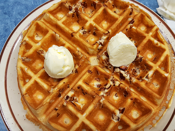 Waffle perfection achieved! Golden, crispy squares cradle pools of melting butter, while a scoop of ice cream stands by, ready to turn breakfast into dessert.