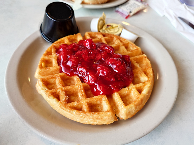 Holy waffle, Batman! This golden disc of deliciousness, crowned with a ruby red strawberry topping, is what breakfast dreams are made of.