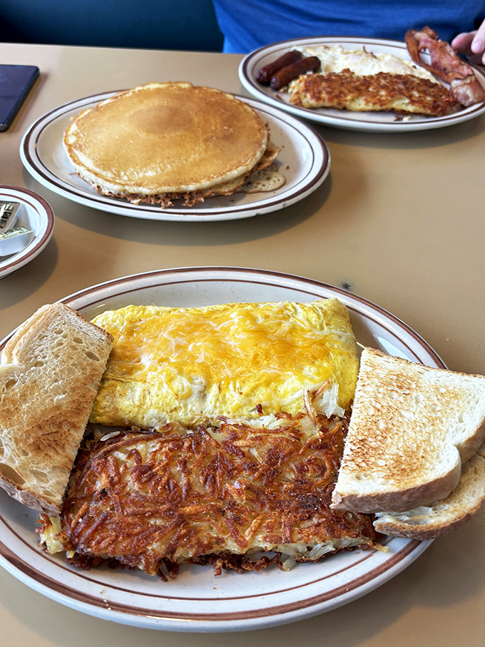 Pancakes so golden, they'd make King Midas jealous. Paired with an omelet that's fluffier than a cloud's pillow, this plate is breakfast nirvana.
