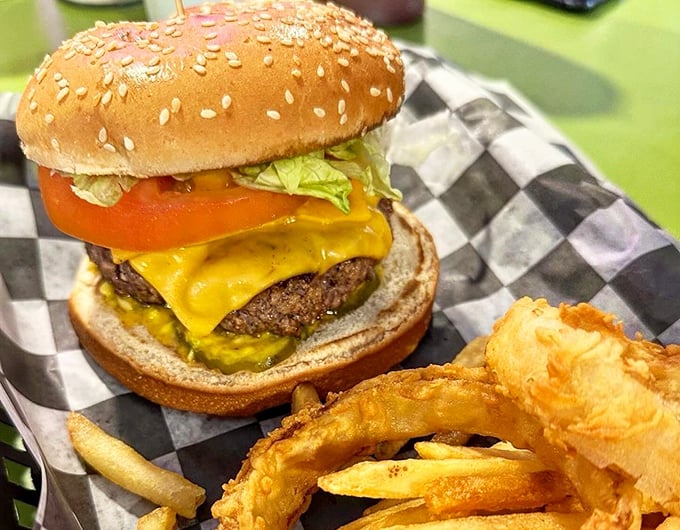 Behold, the burger of your dreams! This juicy masterpiece is stacked higher than a Jenga tower, with melty cheese cascading down like a yellow waterfall.