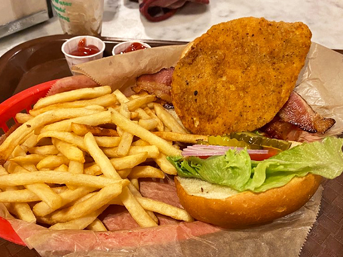 Holy crispy chicken, Batman! This sandwich looks like it could single-handedly fuel your entire road trip across South Dakota. Those golden fries are the Robin to its caped crusader.