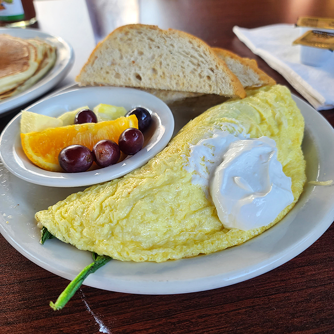 Behold, the humble omelet elevated to an art form! This fluffy masterpiece is paired with a side of fruit so fresh, it might just start its own band.