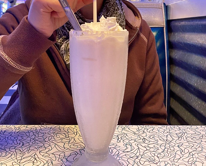 "Thick enough to stand a spoon in! This milkshake isn't just a drink; it's a creamy work of art topped with a cherry crown."