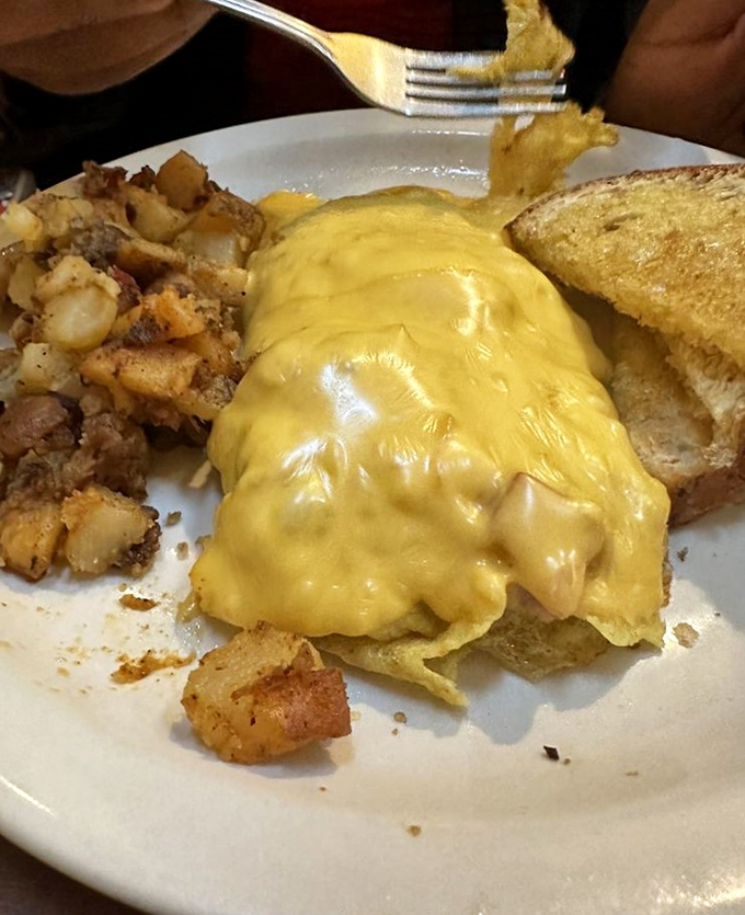 Beware the Cheese Monster! This omelet is so gloriously yellow and gooey, it looks like it's trying to escape the plate. Fork-wielding heroes wanted for this tasty adventure.