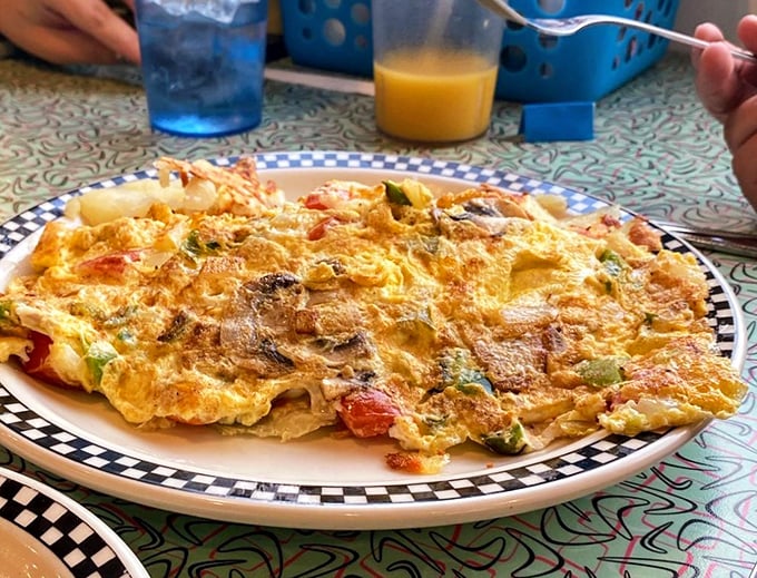 This isn't just an omelet; it's a sunrise captured on a plate. Those perfectly folded eggs housing a garden of vegetables might just make you forget about your cholesterol numbers.