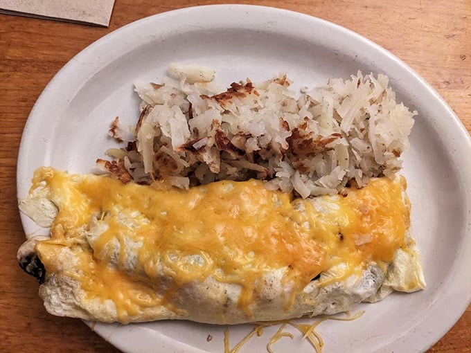 Cheese, please! This omelet is so fluffy and golden, it's like sunshine decided to take a nap on your plate. Hash browns looking crispy-good too!
