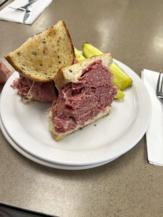 Holy cow! This Reuben isn't just a sandwich, it's a skyscraper of savory satisfaction that'll make your jaw drop (if you can open it wide enough).