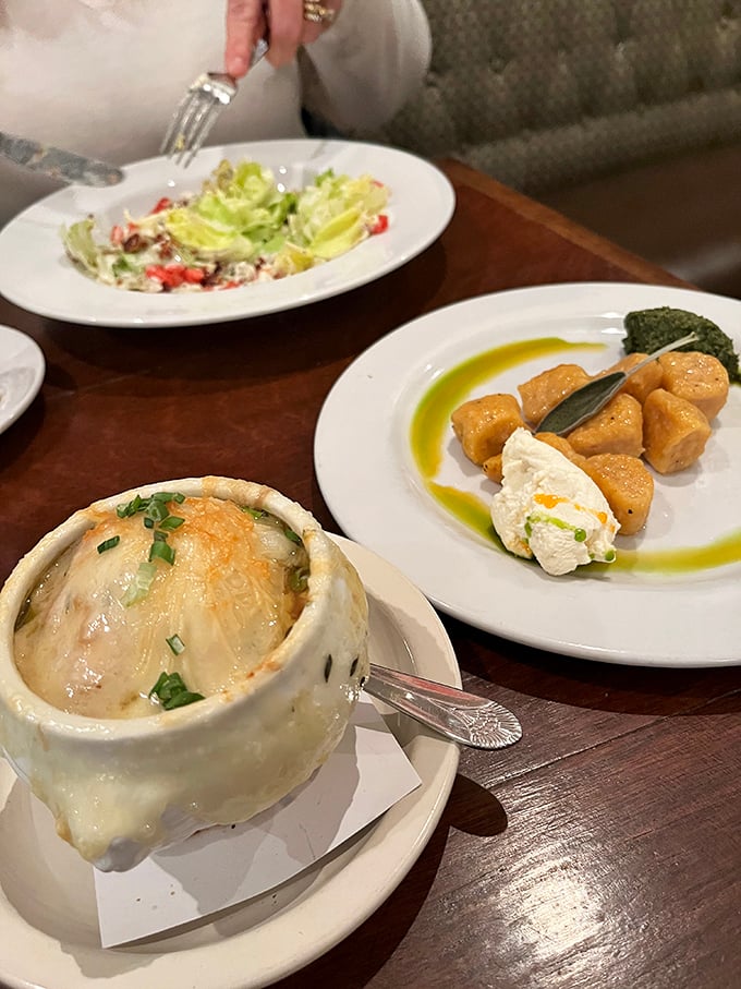 A trio of temptation: French onion soup, wedge salad, and... is that gnocchi? It's like the Avengers of comfort food assembled on one table.