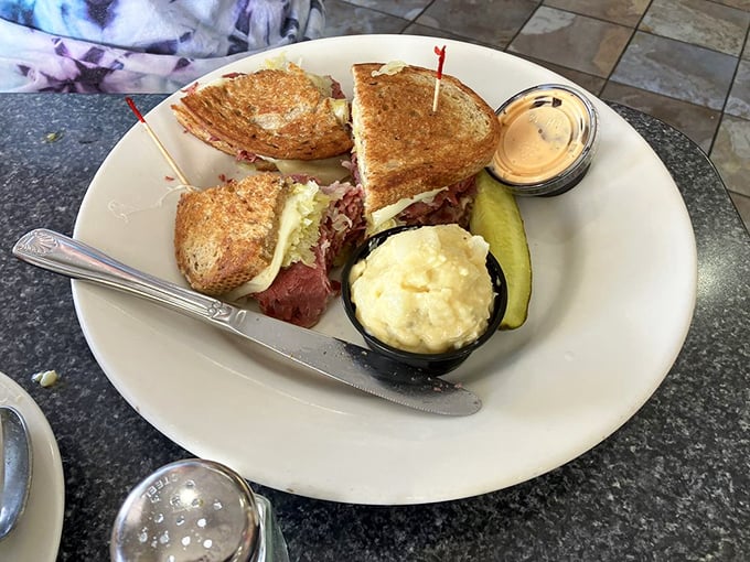 Meat mountain ahead! This Reuben isn't just a sandwich; it's a skyscraper of savory satisfaction.