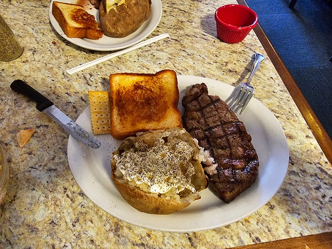 "The holy trinity of comfort: steak, spuds, and toast." This plate is like a warm hug for your taste buds, featuring a juicy steak, a fluffy baked potato, and golden Texas toast.