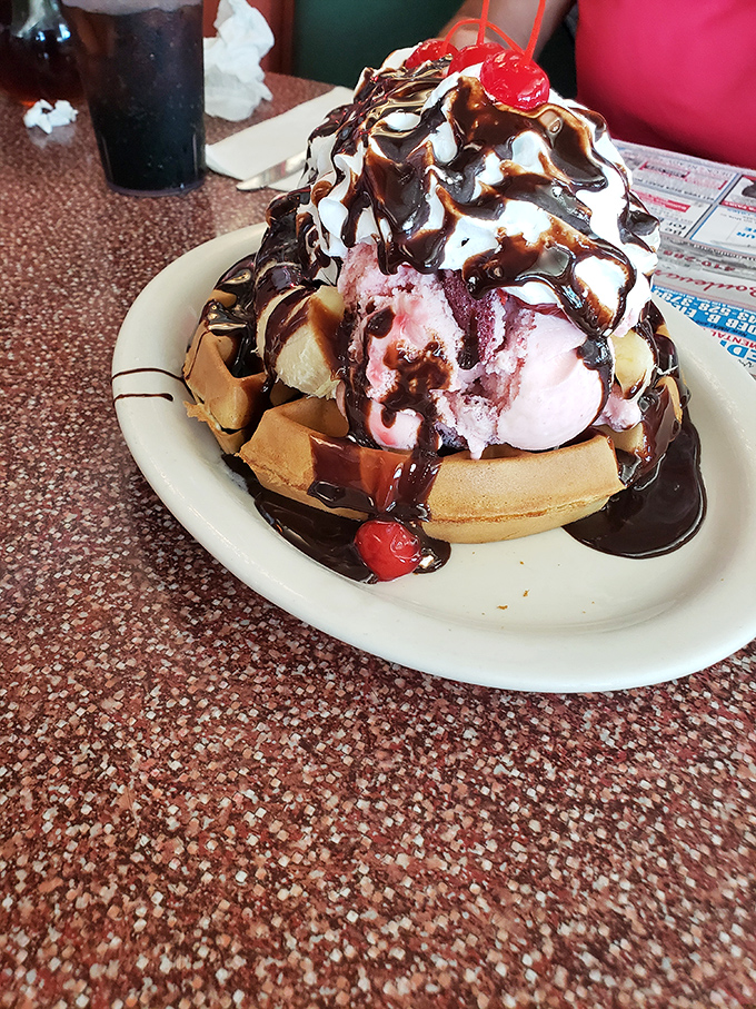 Behold, the leaning tower of dessert! This waffle sundae defies gravity and willpower in equal measure. Resistance is futile.