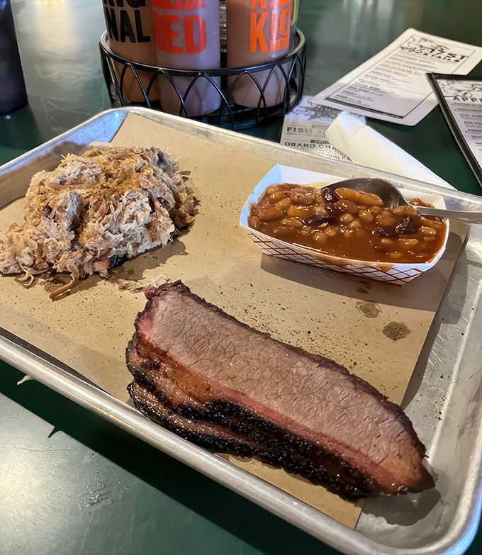 The holy trinity of BBQ: Brisket, pulled pork, and beans. It's like a flavor fiesta in your mouth!