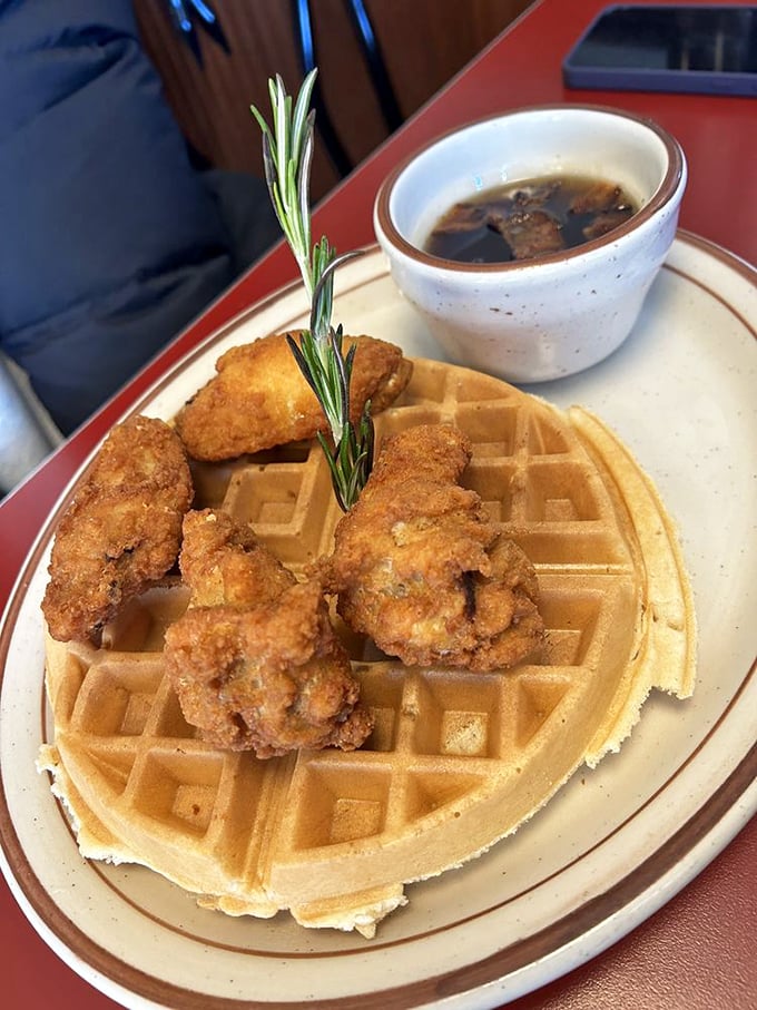 Whoever first decided to pair crispy fried chicken with golden waffles deserves a Nobel Prize. The rosemary sprig is just showing off.