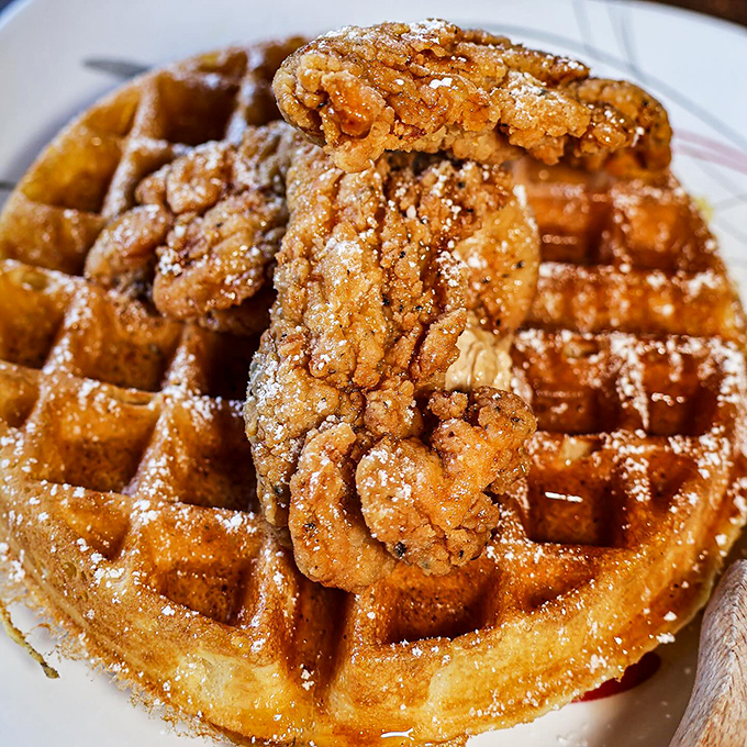 The chicken and waffle defies gravity and good sense&mdash;crispy, golden bird perched atop a Belgian waffle landscape dusted with powdered sugar snow.